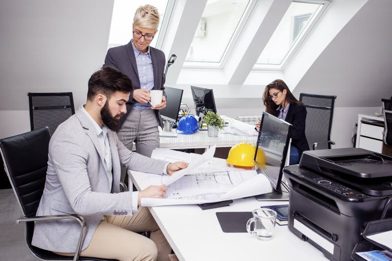 Three Cooworkers with Plans on Table Stock Image - Image of computer ...