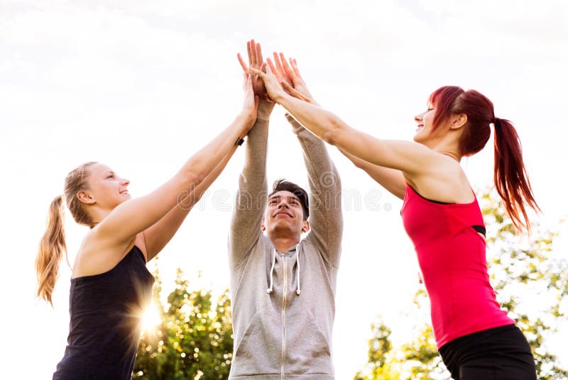 Group of Young Runners in Park Doing High Five Gesture. Stock Photo ...