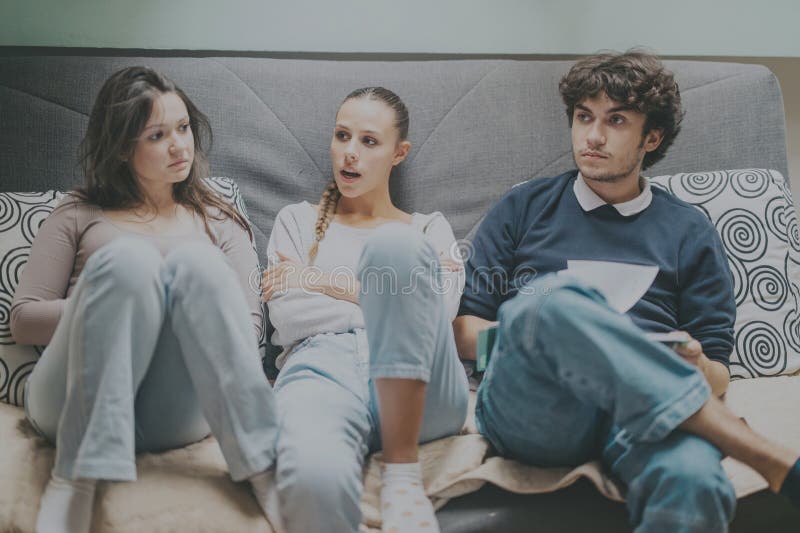 Group of Young Students Having a Serious Discussion on a Couch Stock ...