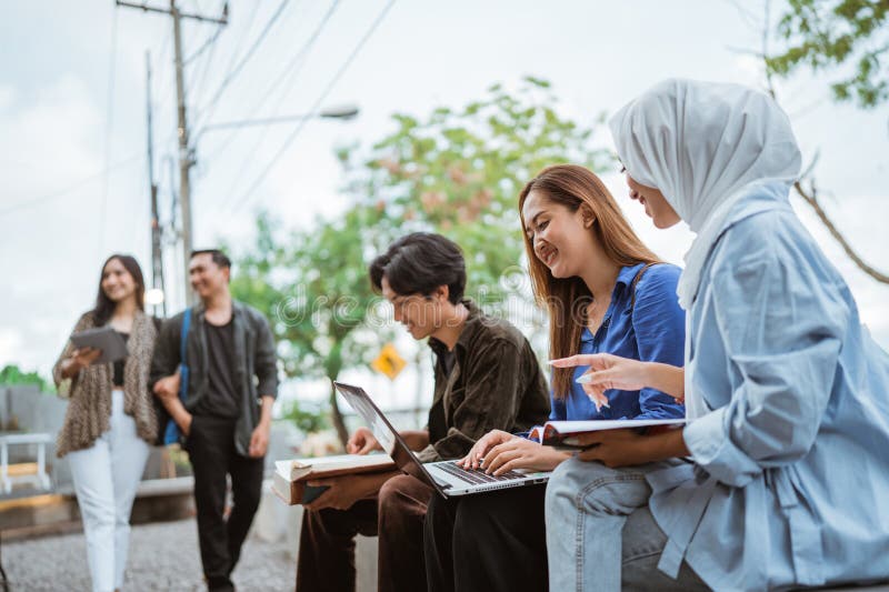 Group of Young Students Studying Using a Laptop in an Outdoor Cafe ...