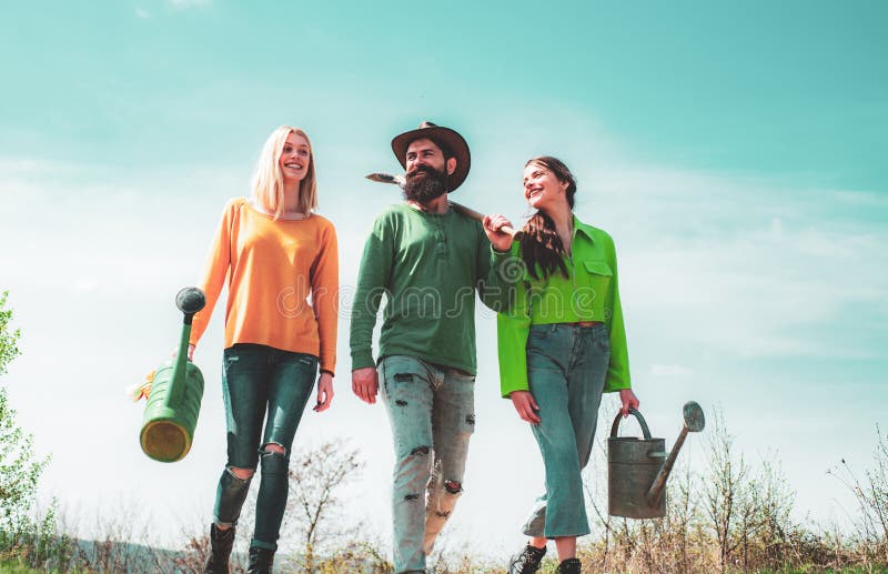 Group of Youth Work in Spring Yard with Garden Tools. People Walking in ...