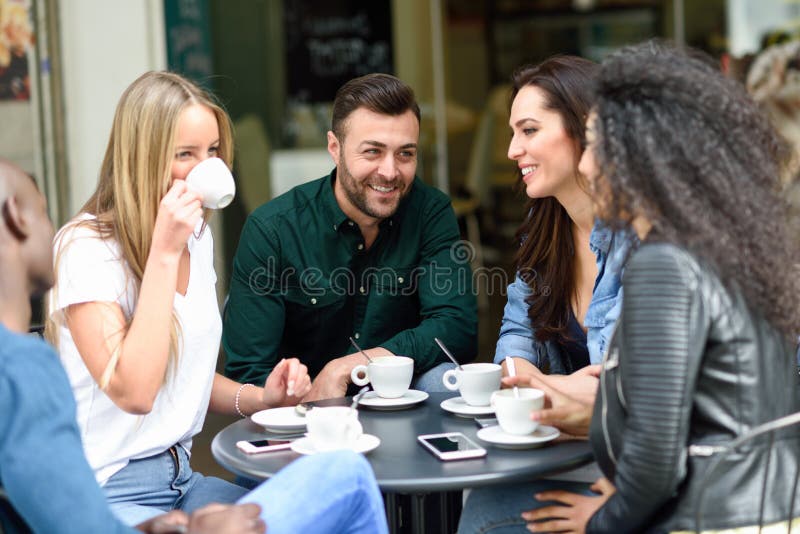 Groupe Multiracial De Cinq Amis Ayant Un Café Ensemble Image stock ...