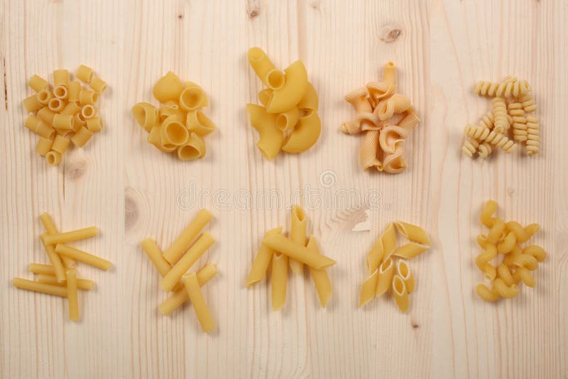 Groups of Different Kinds of Dry Uncooked Pasta on a Wooden Table Stock ...