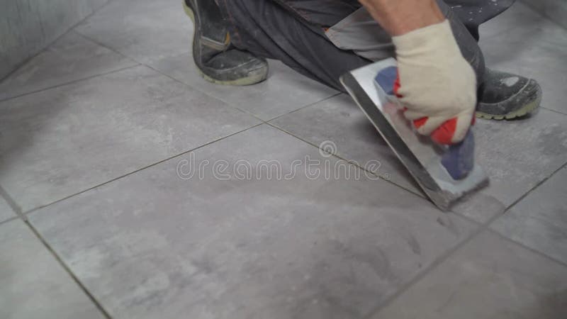 Grouting Ceramic Tiles. Tilers Filling the Space between Tiles Using a ...