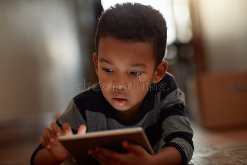 Growing Up with Technology. Shot of a Young Boy Using His Digital ...