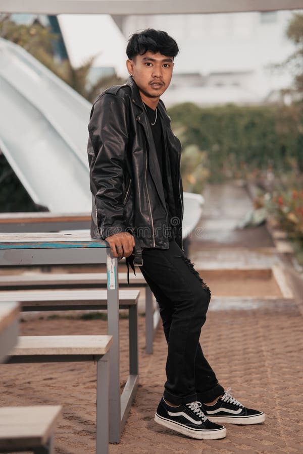 A Grown Man in a Black Leather Suit and Chain Necklace Posing Very ...