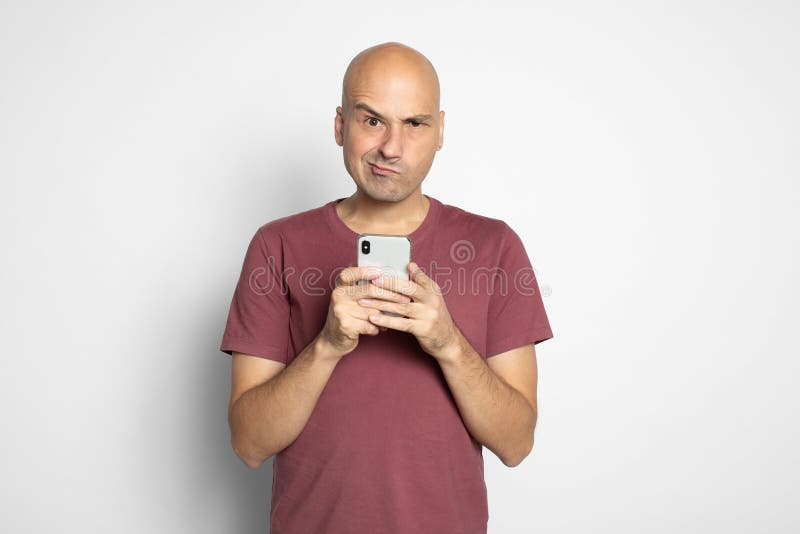 Grumpy Bald Man Holding Smartphone Stock Photo - Image of shirt, casual ...