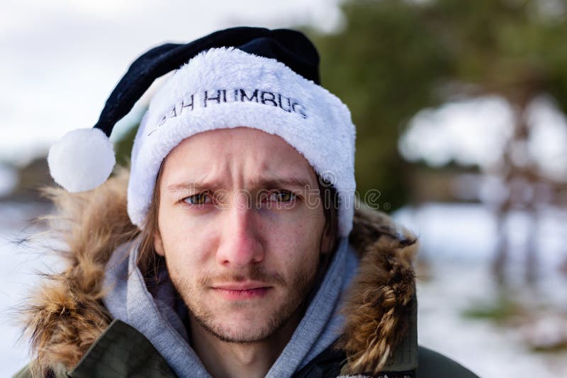 A Grumpy Young Man Wearing a Black Santa Hat with the Words Bah Humbug ...