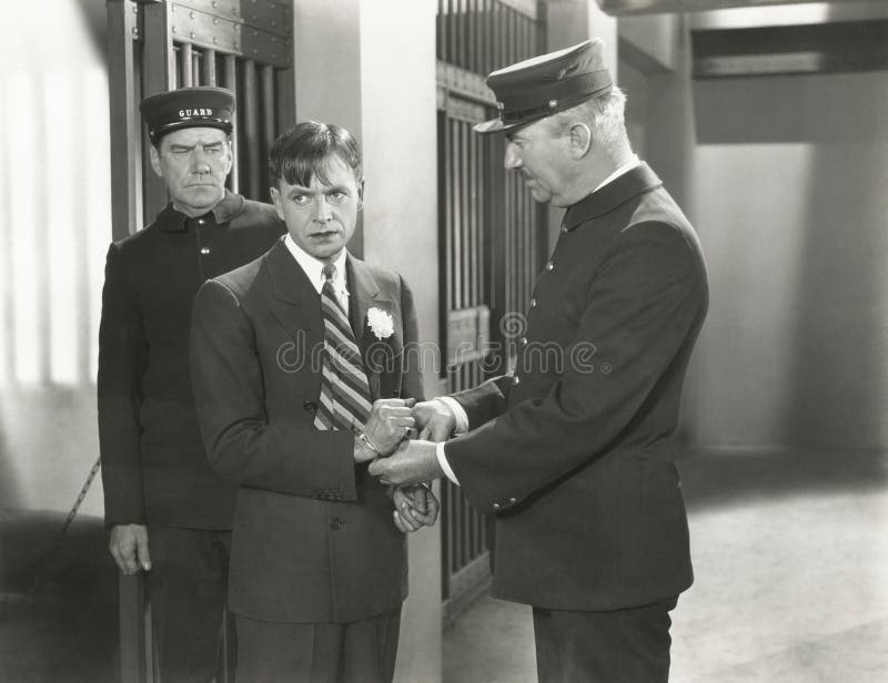 Guard Removing Handcuffs from Prisoner Stock Photo - Image of handcuffs ...