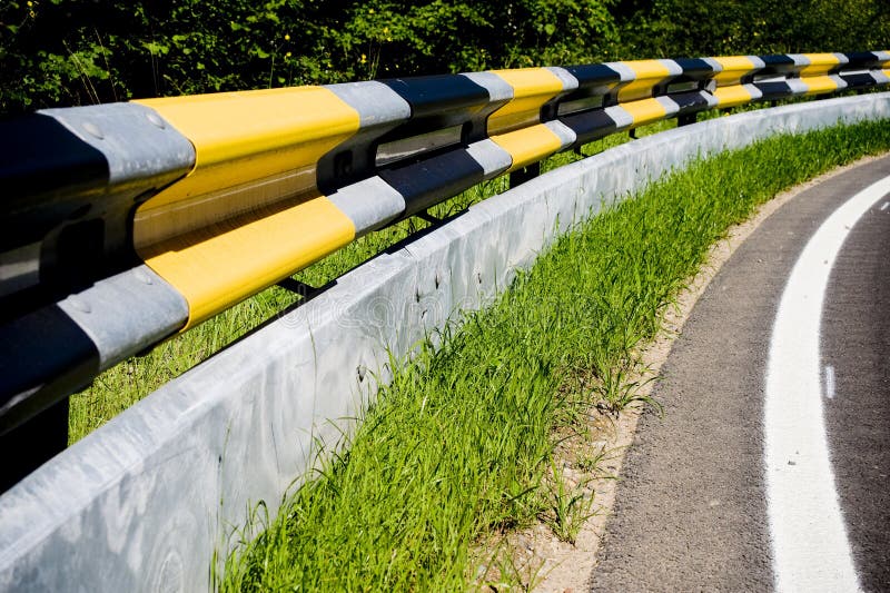 Yellow Guardrail Along Curvy Road With Sunset Over The Sea And Village ...