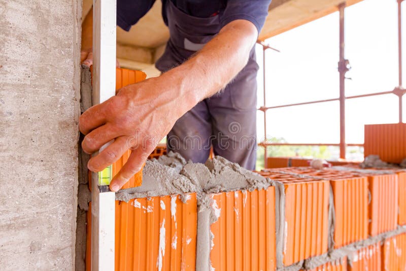 Worker Uses a Spirit Level To Control Wall Made of Red Blocks Stock ...