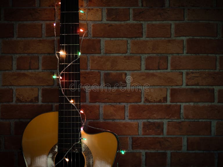 Guitar Wrapped with Glowing String Lights on Brick Wall Stock Image ...
