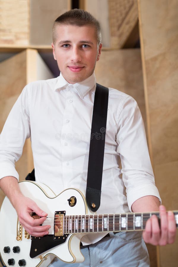 Young Man Playing Guitar Next To the Keyboards Stock Image - Image of ...