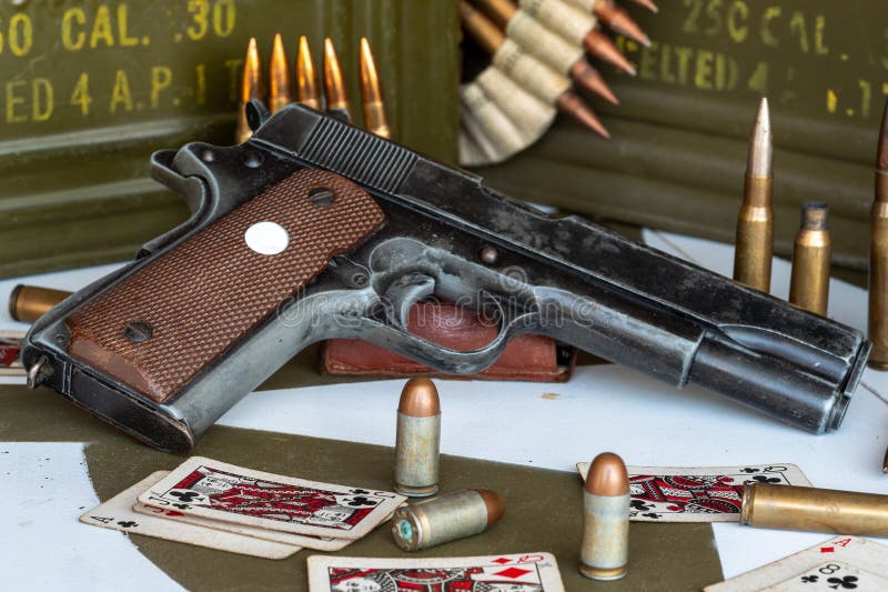 Gun is on a Table with a Pile of Bullets. the Gun is a Colt 45 Stock ...