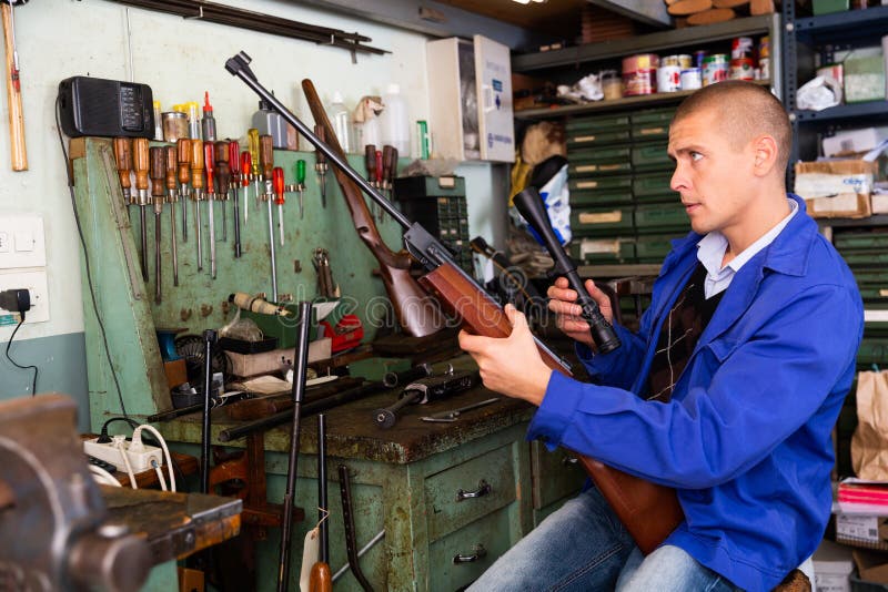 Gunsmith Attaches a Telescopic Sight To Rifle in Weapons Workshop Stock ...
