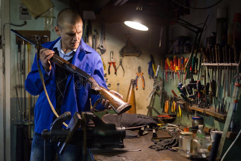 Gunsmith Examines an Automatic Rifle before Being Repaired in Weapons ...