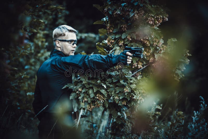 Instructor with Gun in Forest Leads Aiming and Posing on Camera Stock ...