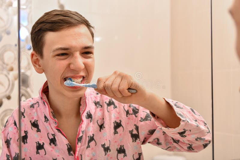 The Guy in the Bathroom Brushes His Teeth with a Toothbrush in Front of ...