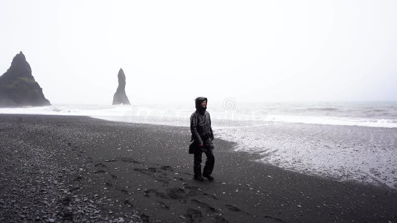 A Guy in a Black Raincoat Walks in the Rain and Storm Along a Black ...