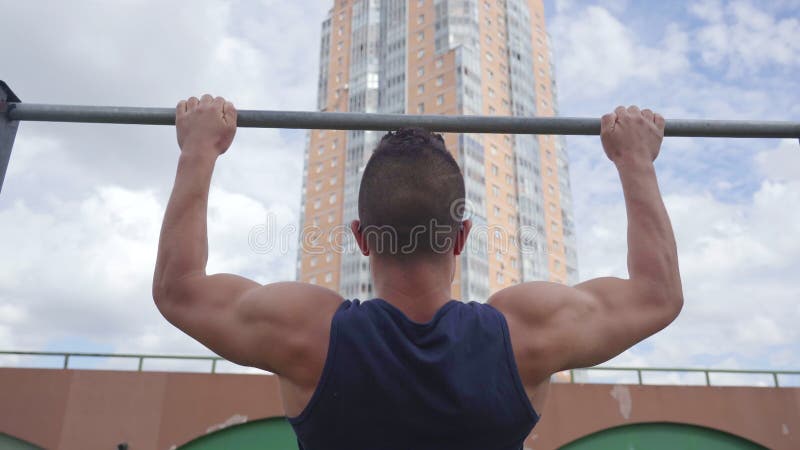 Guy Bodybuilder Pulls Himself Up on the Horizontal Bar. Stock Footage ...