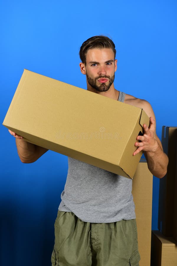 Man Standing Among Cardboard Boxes And Holding One Guy With Beard And