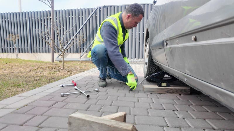 A Guy Changes Tire on Street To Summer Tire in Nature Stock Video ...