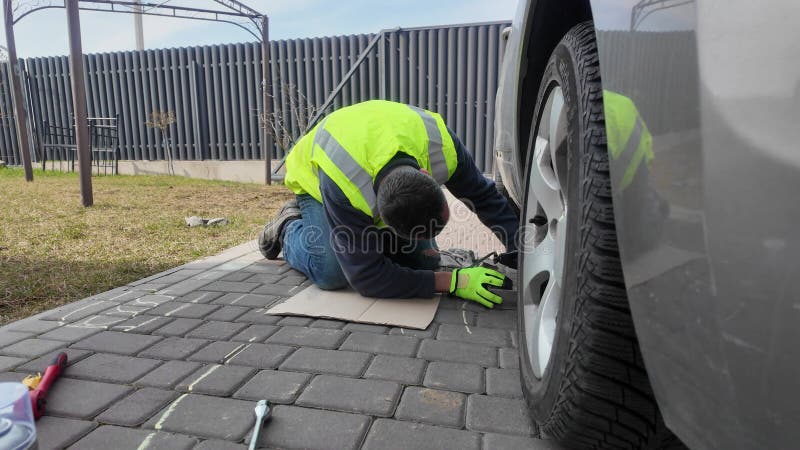 A Guy Changes Tire on Street To Summer Tire in Nature Stock Footage ...