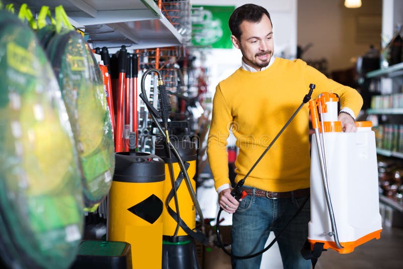 Guy is Considering an Assortment of Garden Sprayers Stock Photo - Image ...