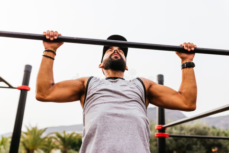 Guy doing pull-ups on pole stock image. Image of glow - 228242099