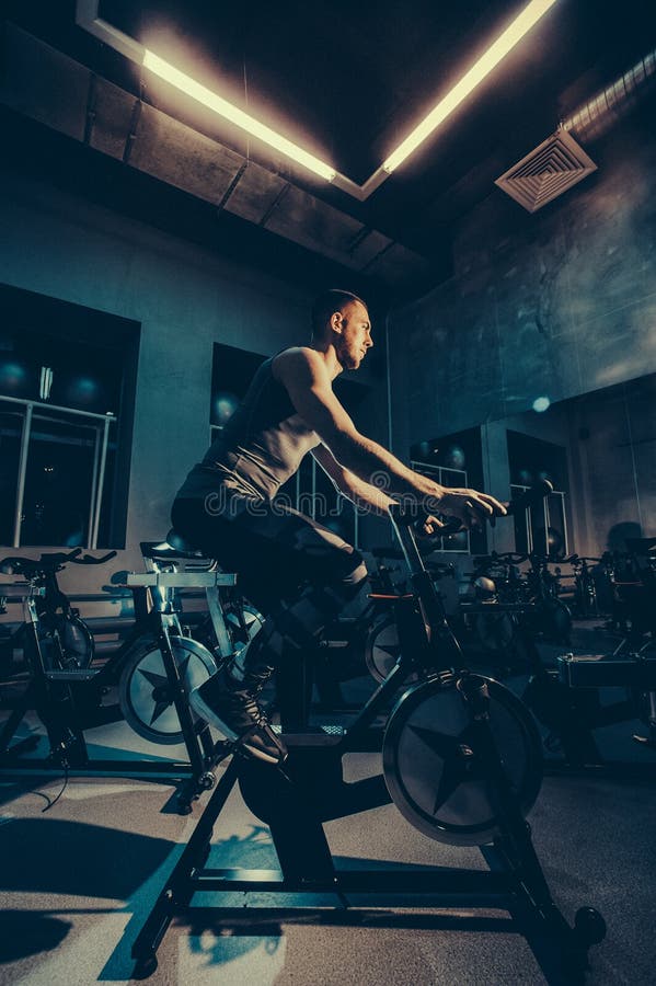 The Guy is Engaged in a Bicycle Simulator in the Gym. Toned Image Stock ...