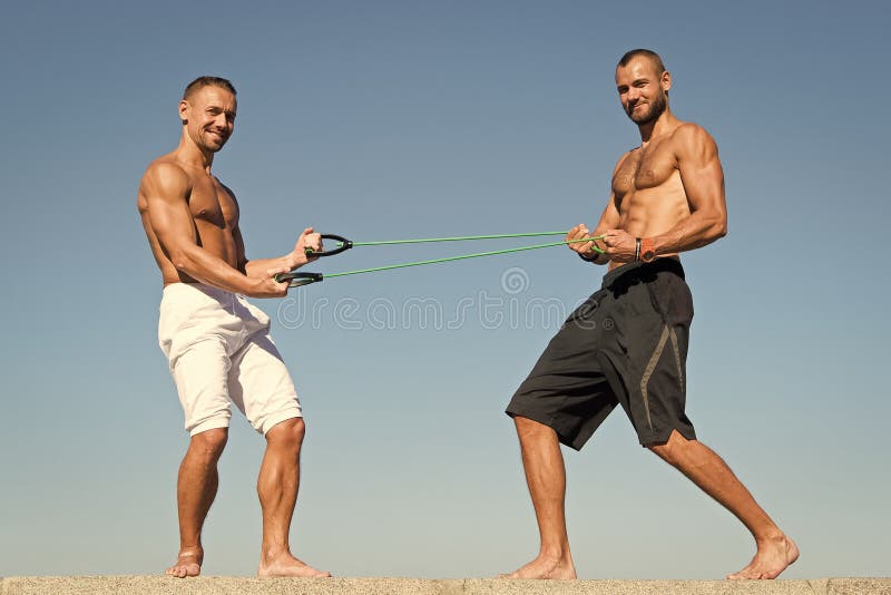 Guy with Expander Equipment Training Stretching with Friend. Stretching ...