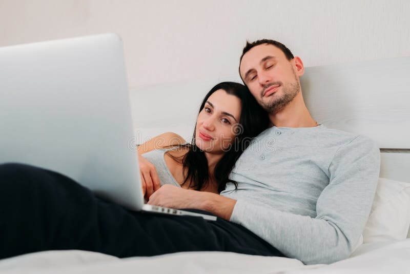 Guy and Girl in Bed are Watching Movie Using Laptop Computer. Stock ...