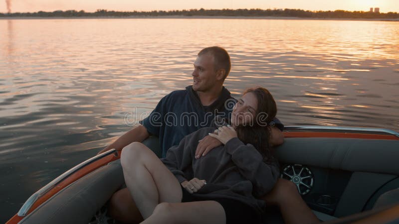 A Guy and a Girl Cuddle Cute at Sunset Sitting in a Boat Stock Video ...