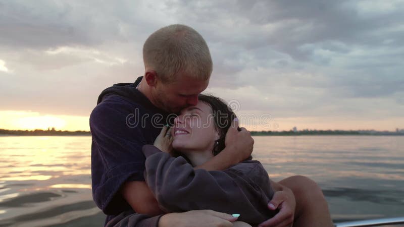A Guy and a Girl Cuddle Cute at Sunset Sitting in a Boat Stock Video ...
