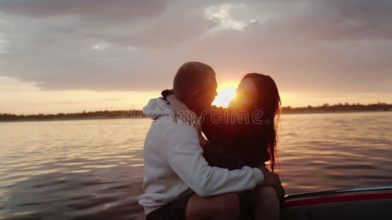 A Guy and a Girl Cuddle Cute at Sunset Sitting in a Boat Stock Footage ...