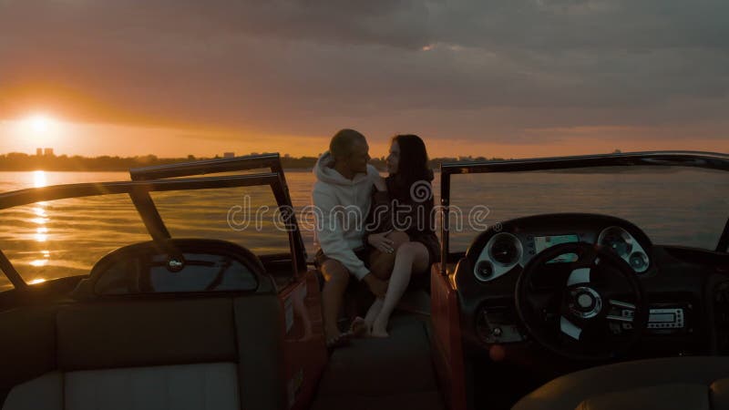 A Guy and a Girl Cuddle Cute at Sunset Sitting in a Boat Stock Footage ...
