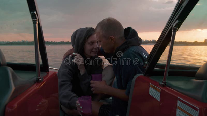 A Guy and a Girl Cuddle Cute at Sunset Sitting in a Boat Stock Video ...