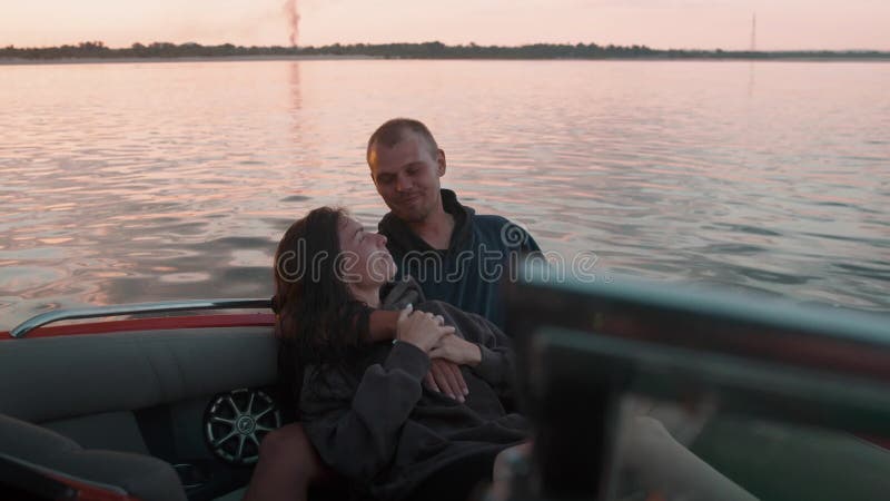 A Guy and a Girl Cuddle Cute at Sunset Sitting in a Boat Stock Footage ...