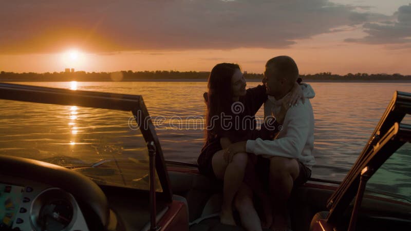A Guy and a Girl Cuddle Cute at Sunset Sitting in a Boat Stock Video ...
