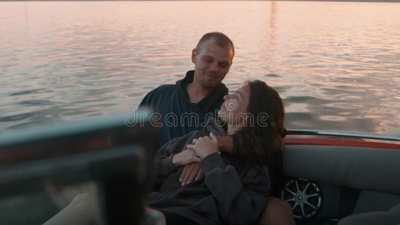 A Guy and a Girl Cuddle Cute at Sunset Sitting in a Boat Stock Video ...