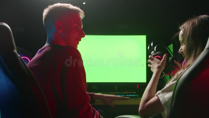 A Guy and a Girl are Sitting at a Computer and Looking at a Green ...