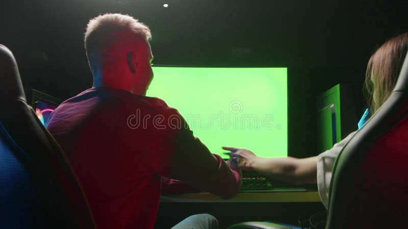 A Guy and a Girl are Sitting at a Computer and Looking at a Green ...