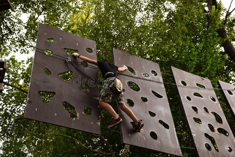 The Guy Goes through the Obstacle Course on the Rope Park Stock Photo ... The Guy Goes through the Obstacle Course on the Rope Park Stock Photo ...