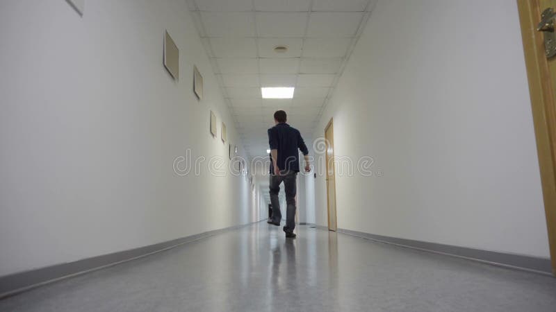 Guy Goes Strange Gait in the Long White Corridor Stock Footage - Video ...