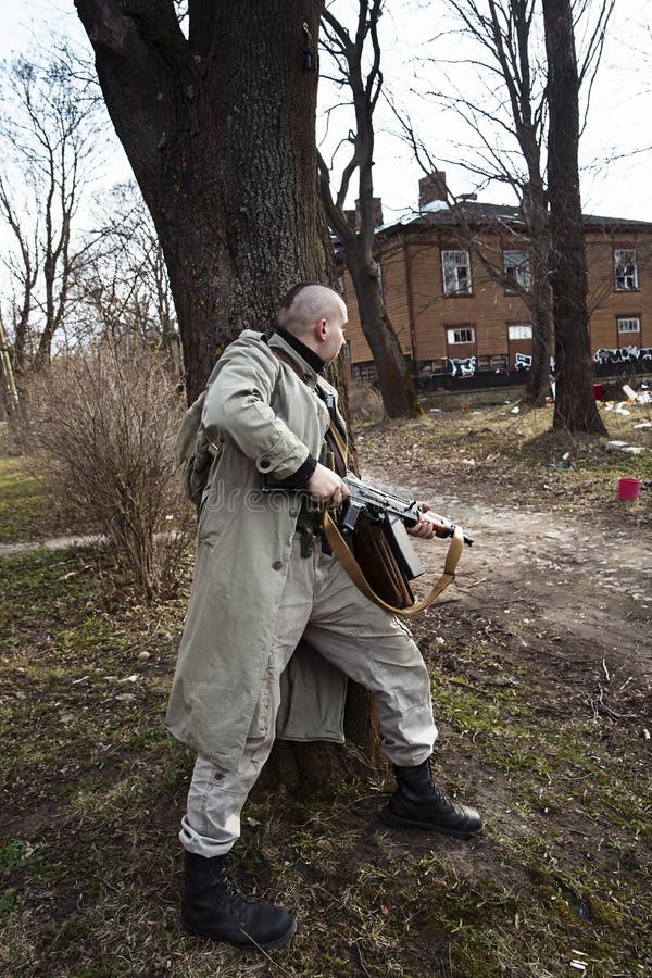 A Guy with the Gun Waiting for Someone Leaned on the Tree Stock Image ...