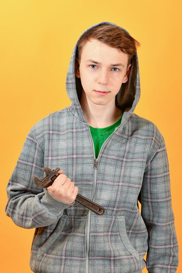 The Guy in the Hood Holds an Adjustable Wrench in His Hand on a Stock ...