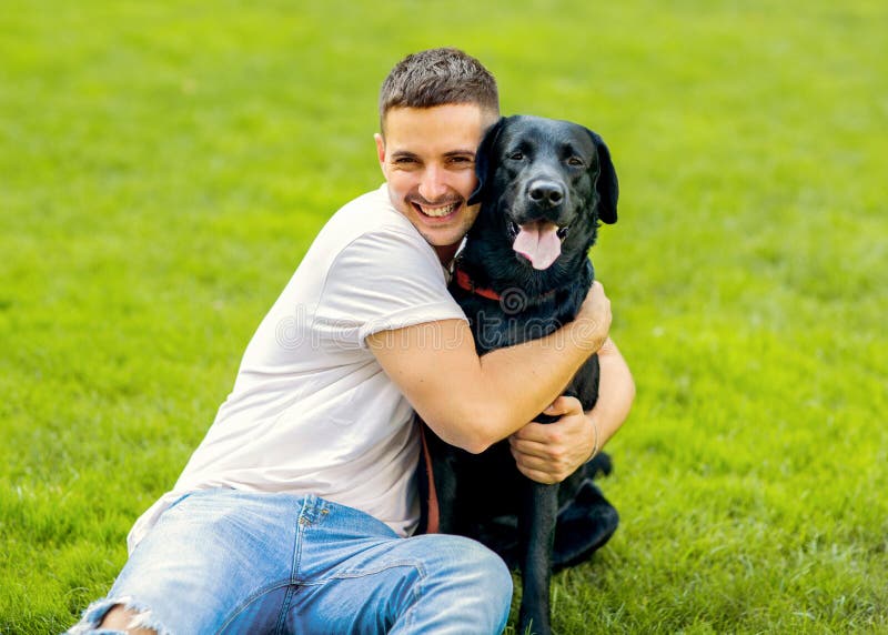 Guy Hugging with His Dog Labrador Playing in the Park Stock Photo ...