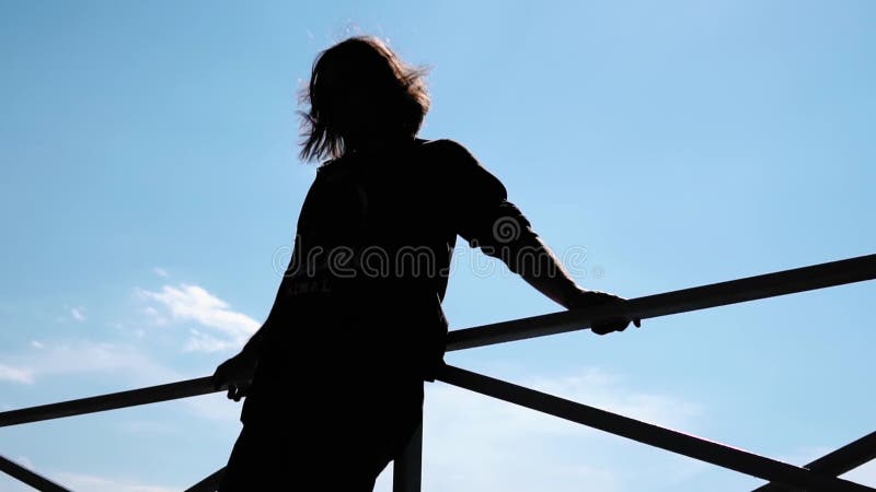 The Guy is Leaning Back Against the Railing Against the Beautiful Sky ...