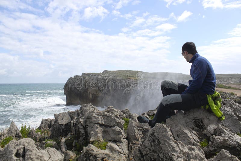 Guy Looking at the Waves Splashing the Rocks Stock Photo - Image of ...