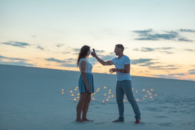 The Guy Makes the Girl a Marriage Proposal at Evening in Sand Desert ...